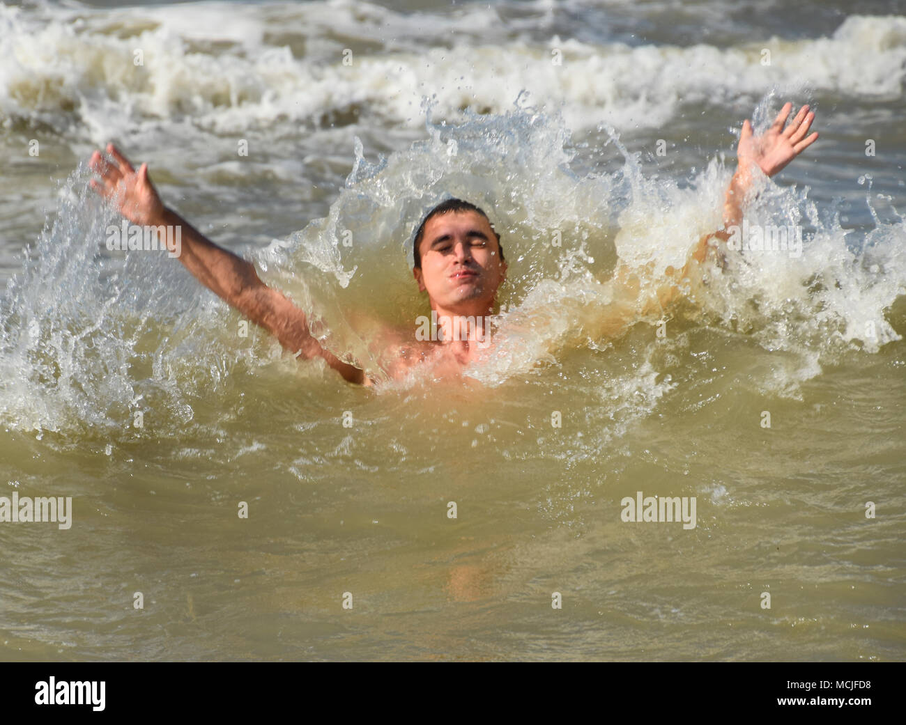Athletic man in sea water. Bathing in the sea. A man is swimming among ...