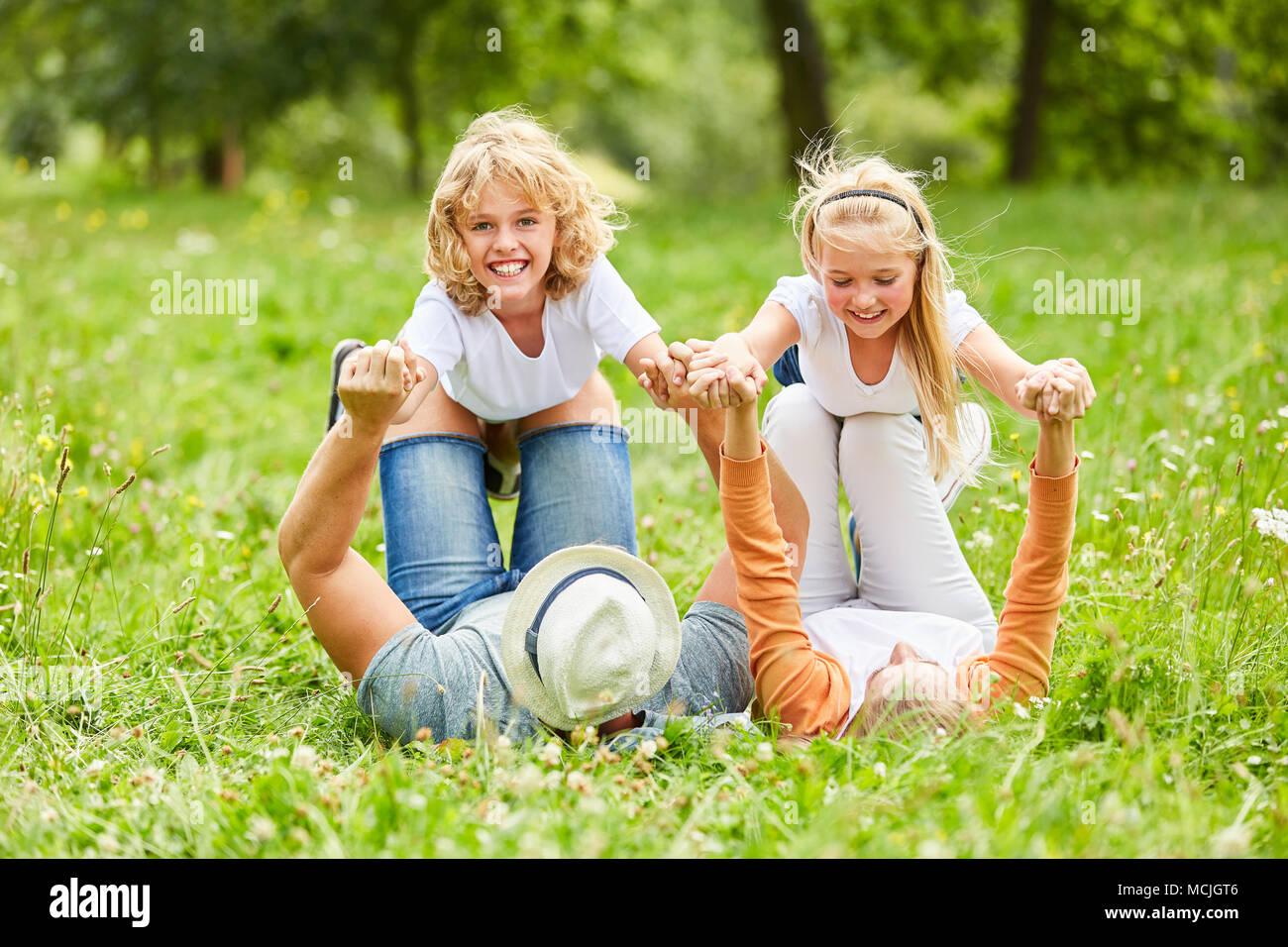 Family and siblings Children play on a meadow in summer Stock Photo - Alamy
