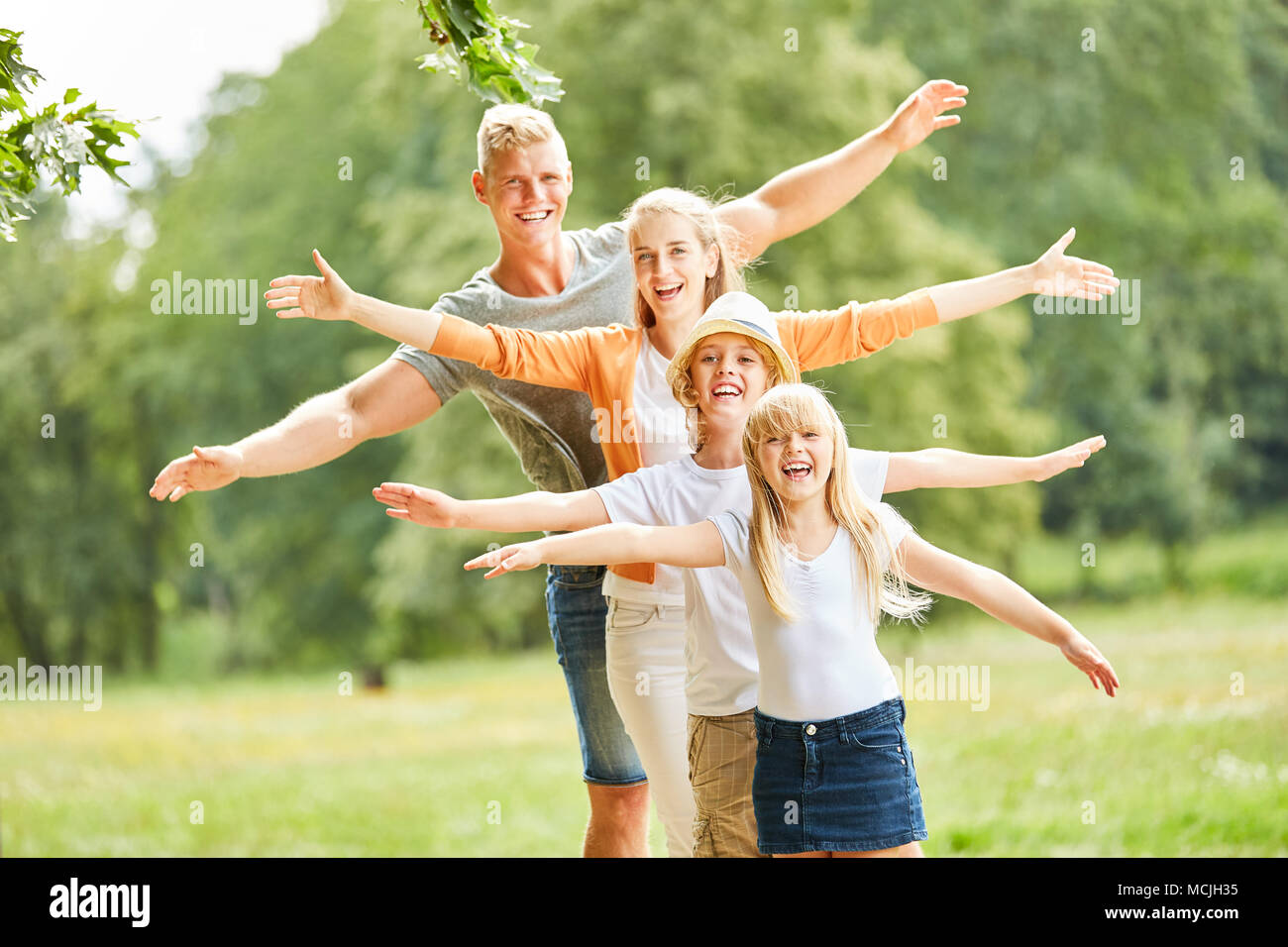Happy active family and children are balancing with outstretched arms ...