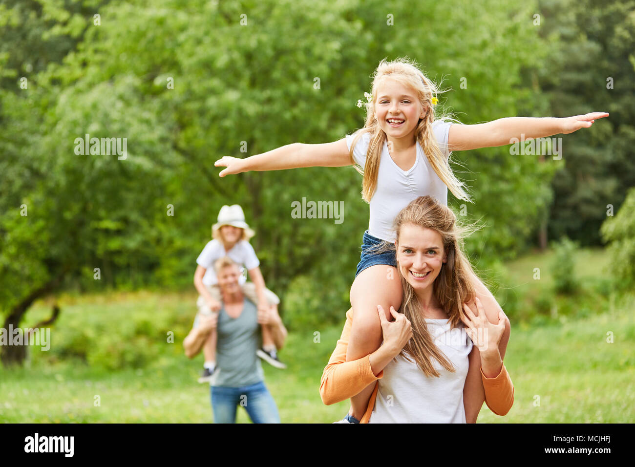 Happy girl riding piggyback on the shoulders of the mother Stock Photo ...