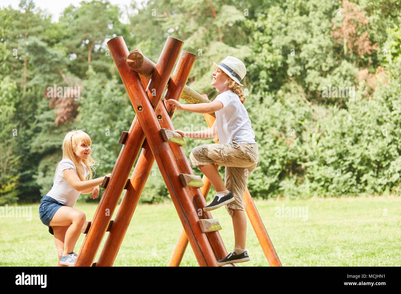 Two children climb on a climbing frame on a playground in the ...
