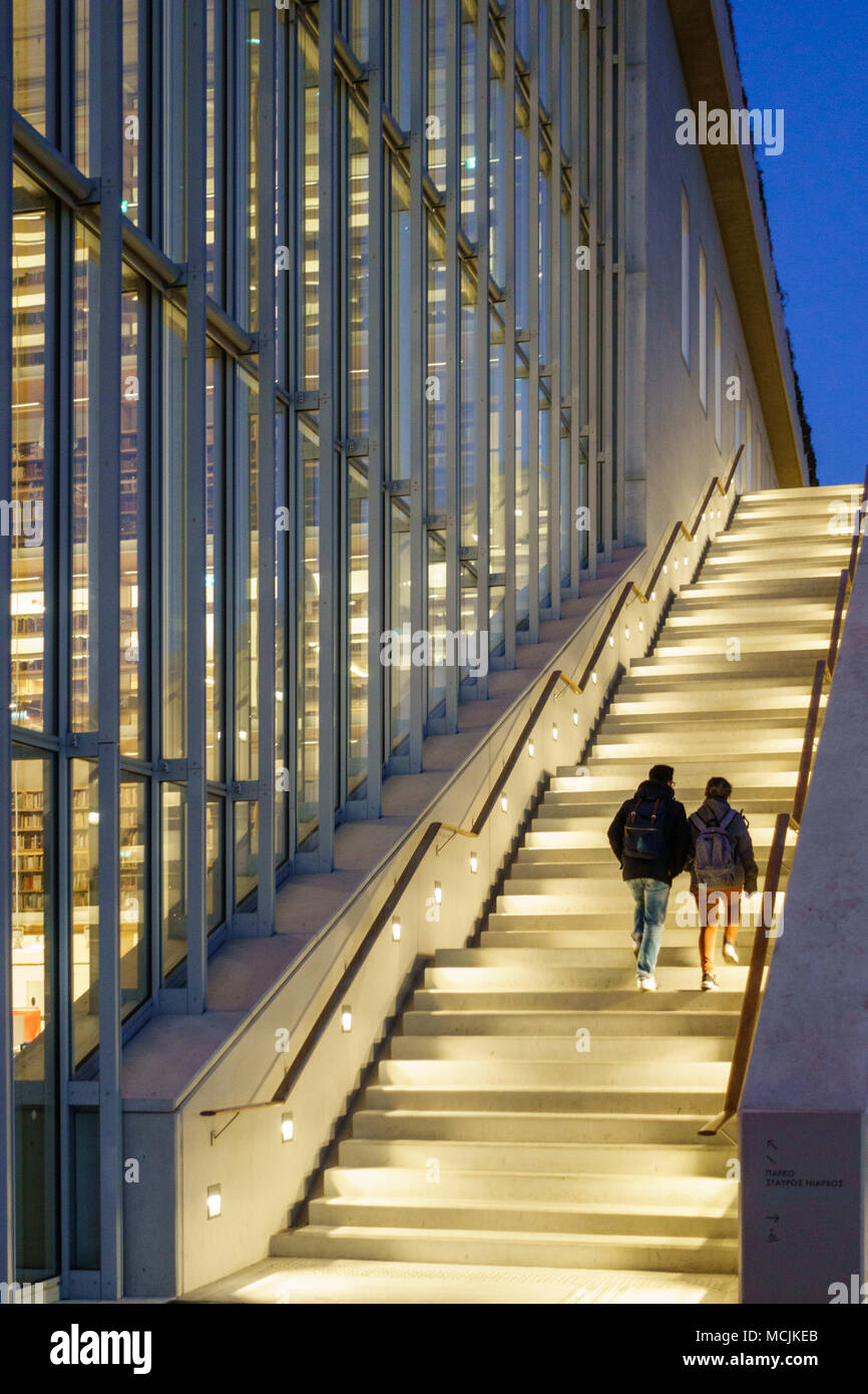 Rear view of couple climbing illuminated stairs at Stavros Niarchos ...