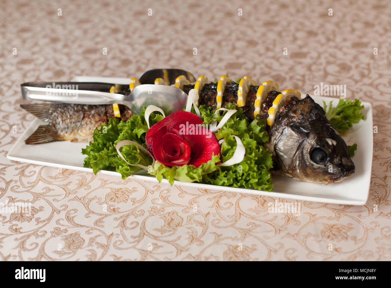 Delicious stuffed carp with lemon. Gefilte fish with lettuce leaves ...