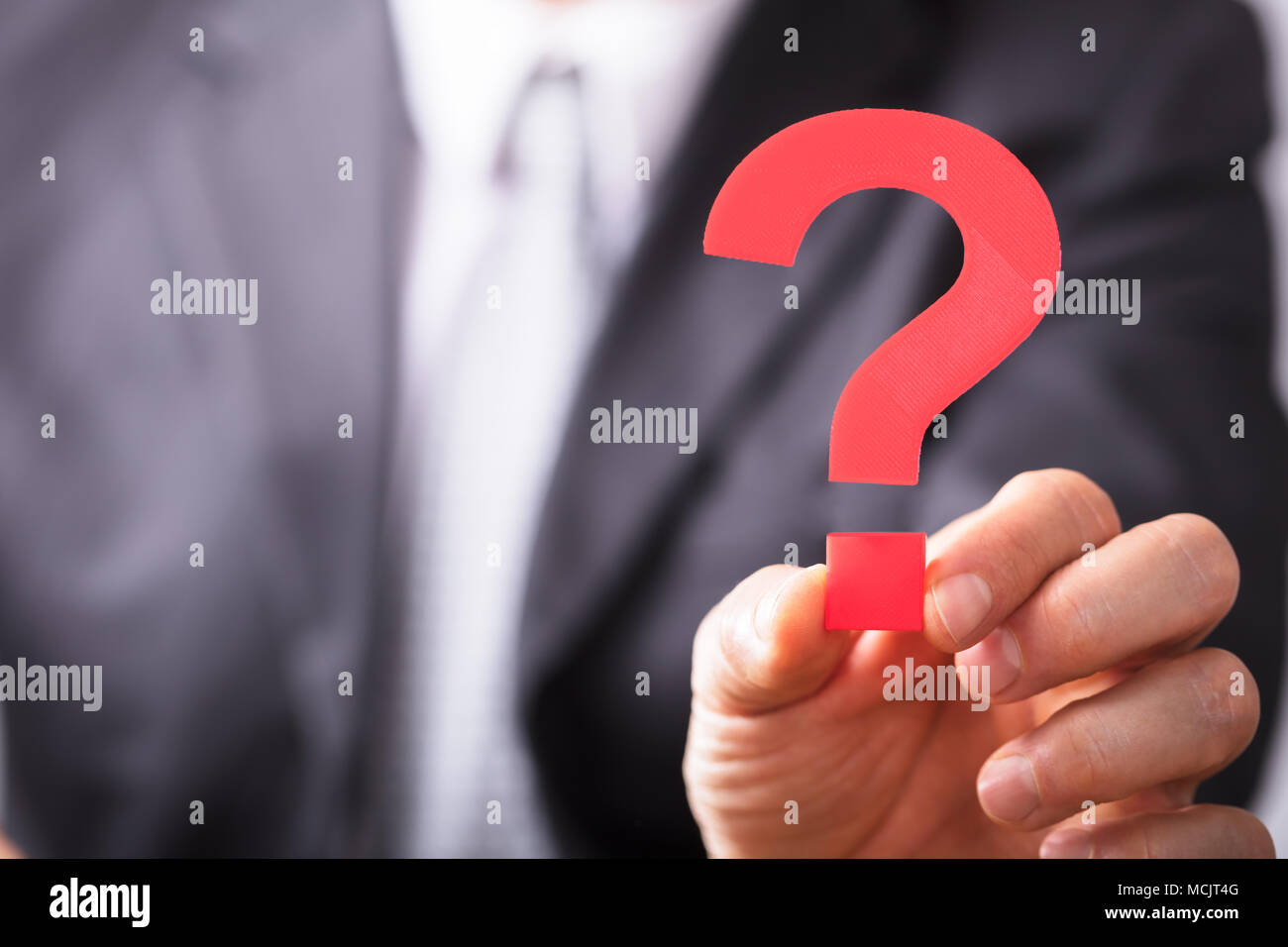Business man hold a red question mark hi-res stock photography and ...