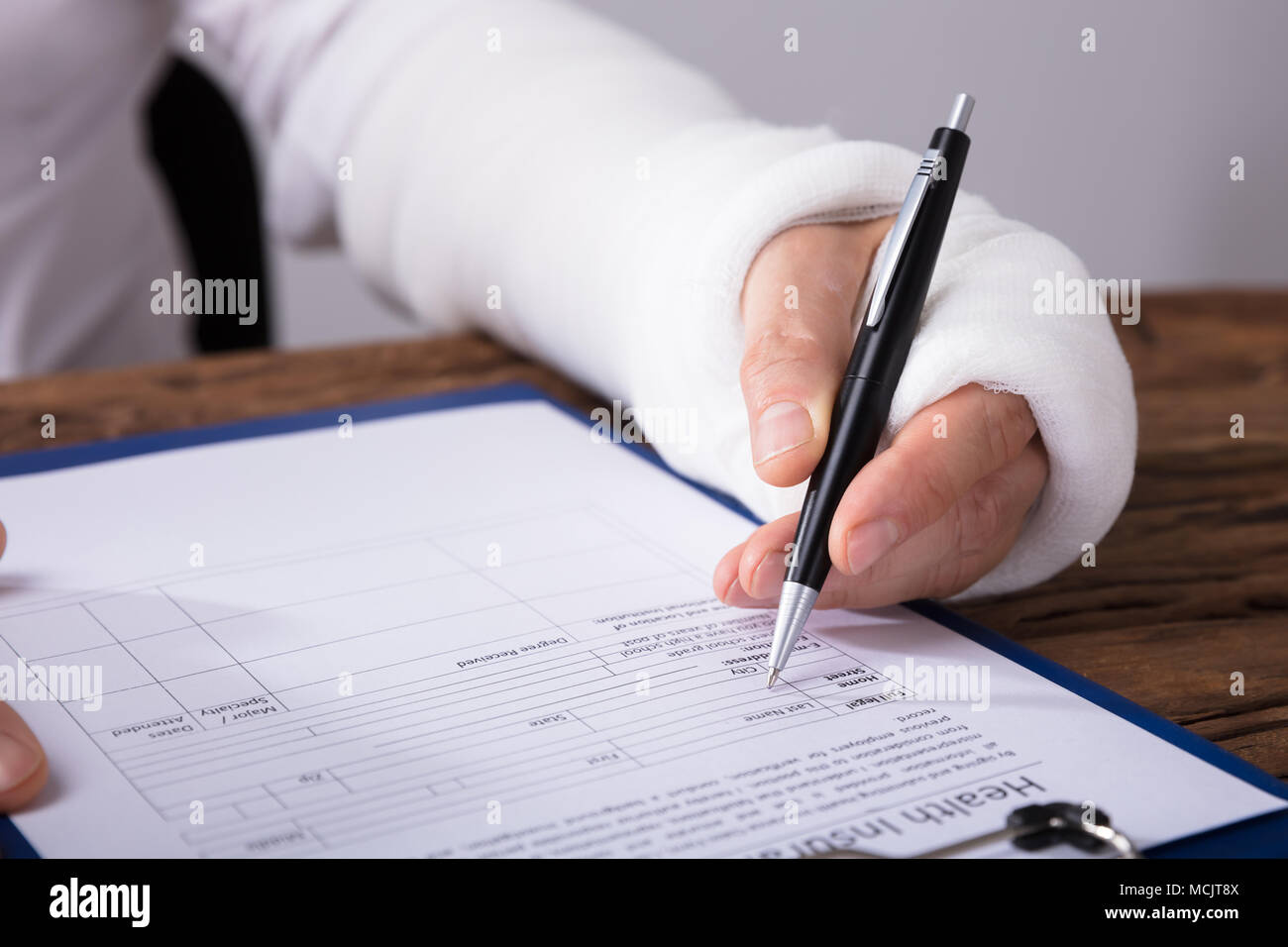 Close-up Of A Businessperson With Broken Arm Filling Health Insurance ...