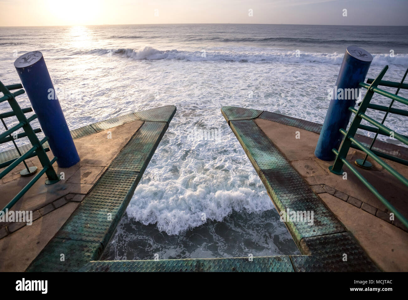 Pier structure in the morning light looking out to sea with waves ...