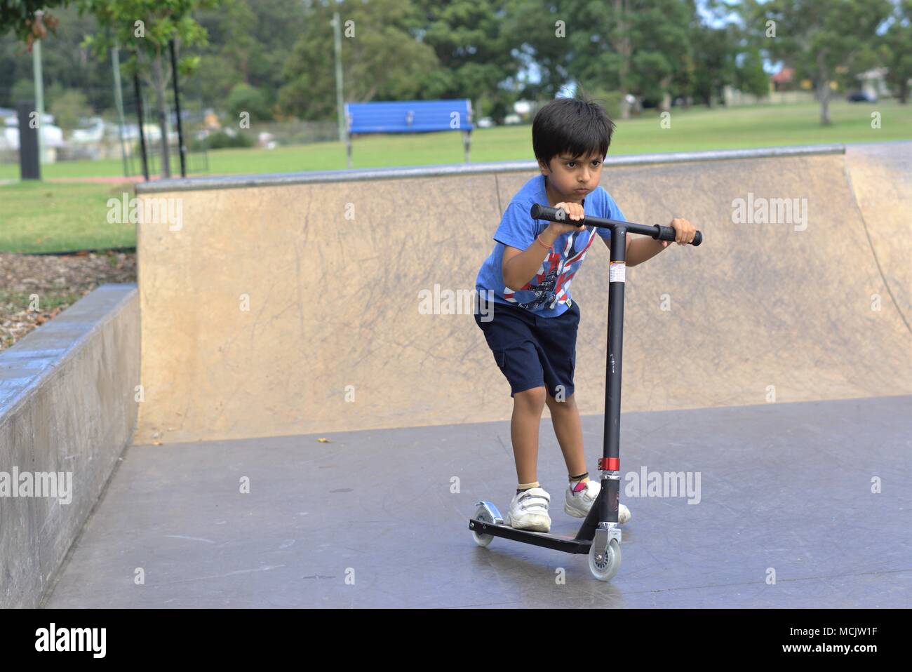Boy playing with scooter. Kid riding scooter in park. Child riding ...