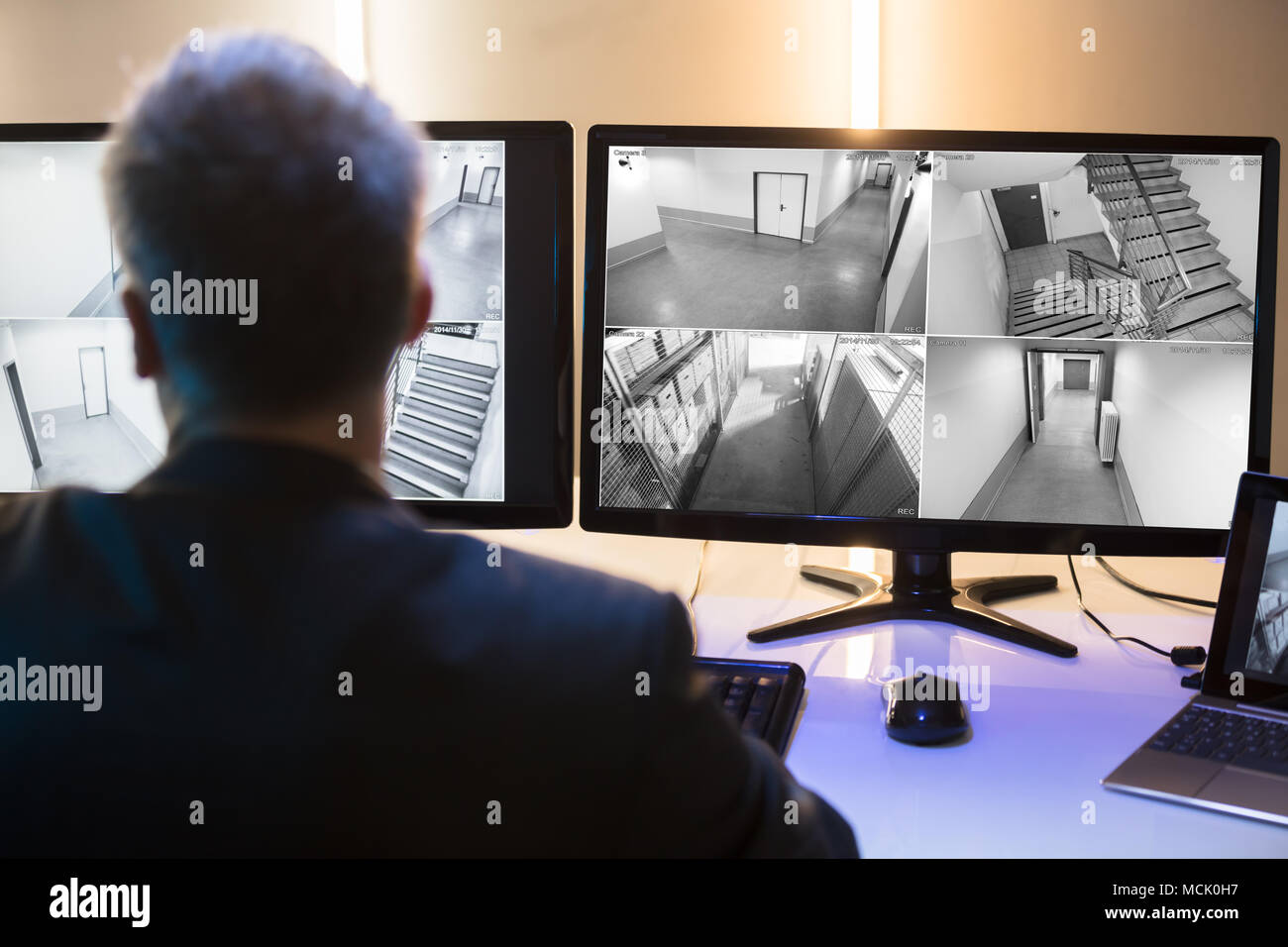 Side View Of A Mature Businessman Looking At CCTV Camera Footage On ...