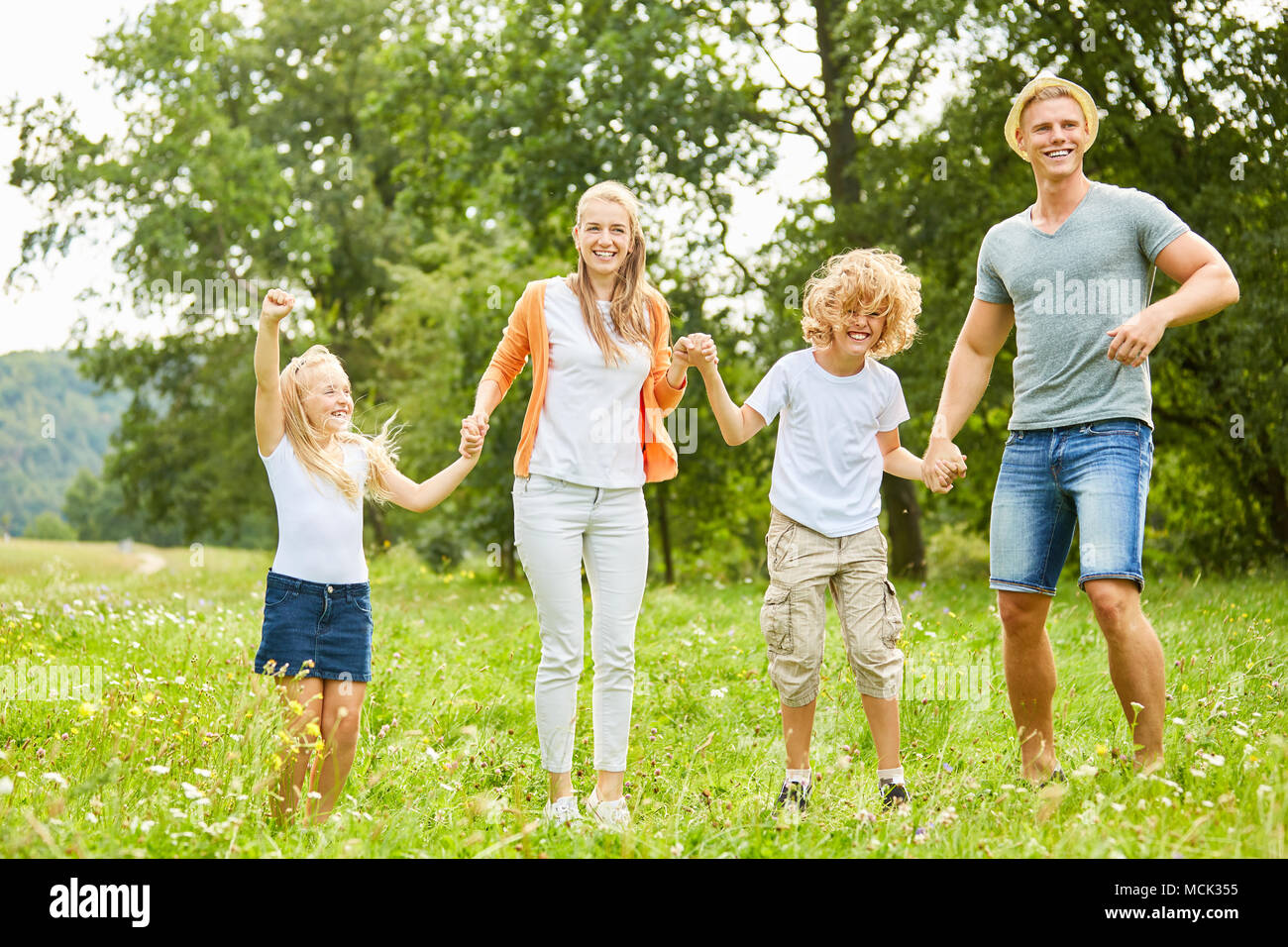 Family and children laugh and dance together happily in the garden ...