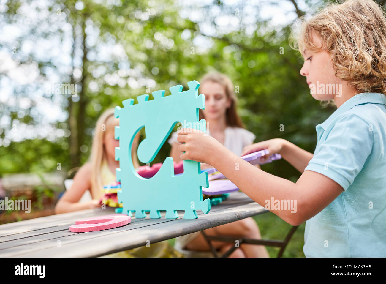 Children build a miniature house from colorful puzzle pieces Stock ...