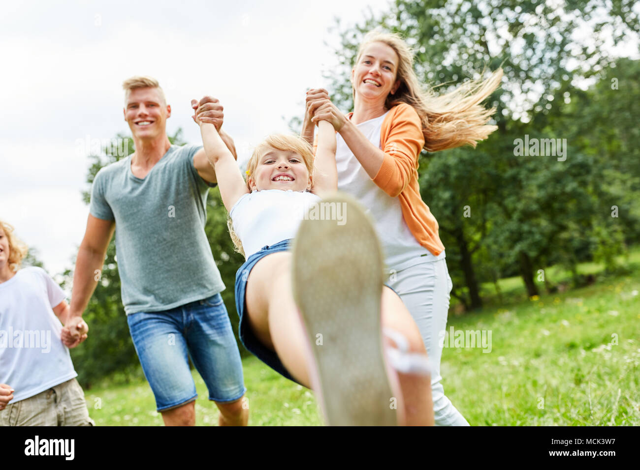 Parents play and romp with their children in the garden in summer Stock ...