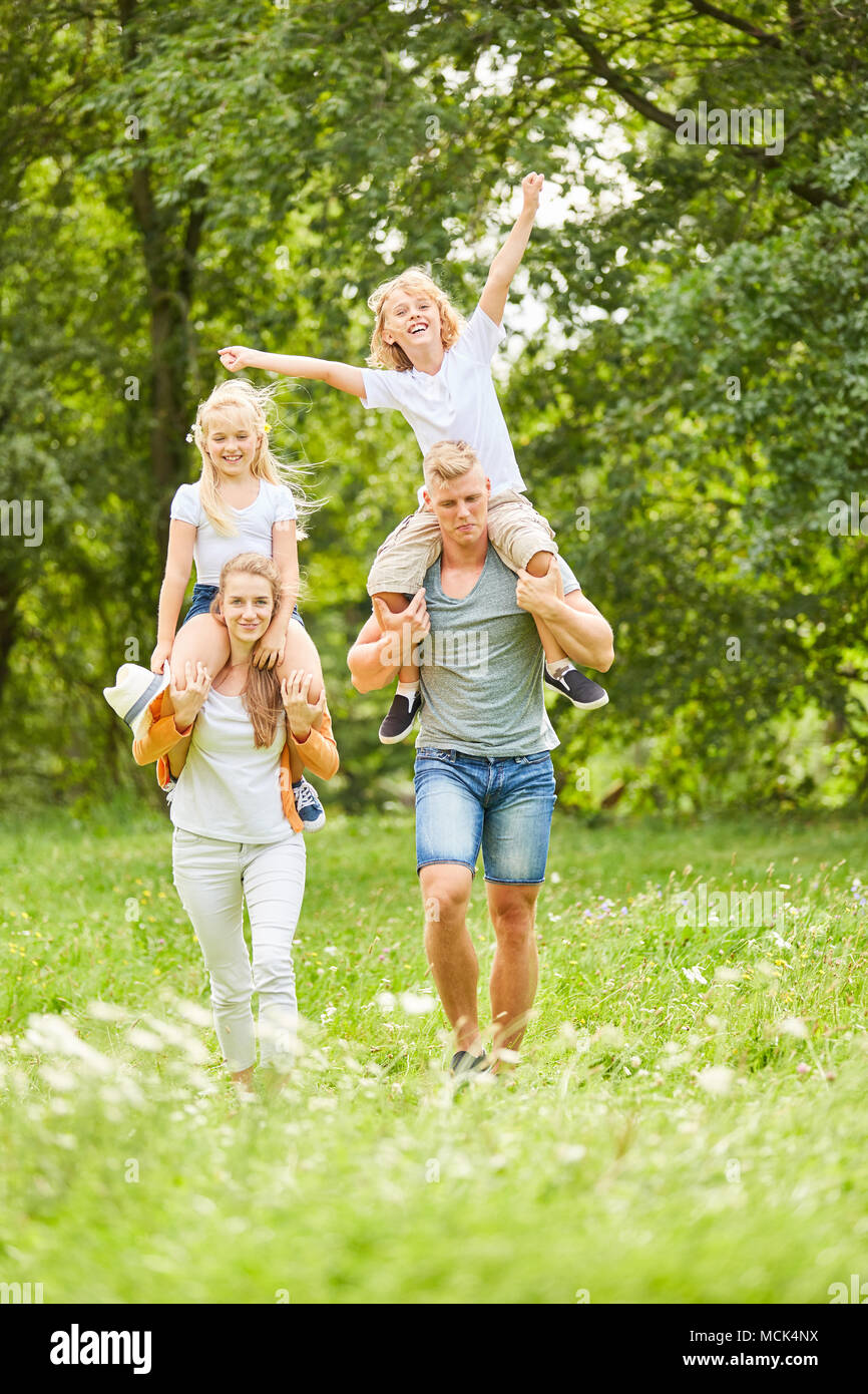 Parents go on a nature excursion and piggyback their children Stock ...