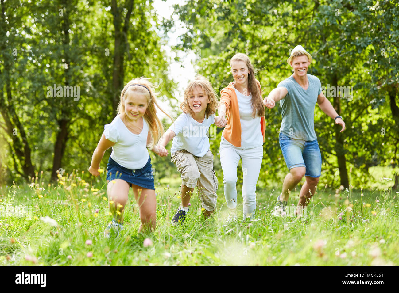 Happy family and kids run together in the garden in summer Stock Photo ...