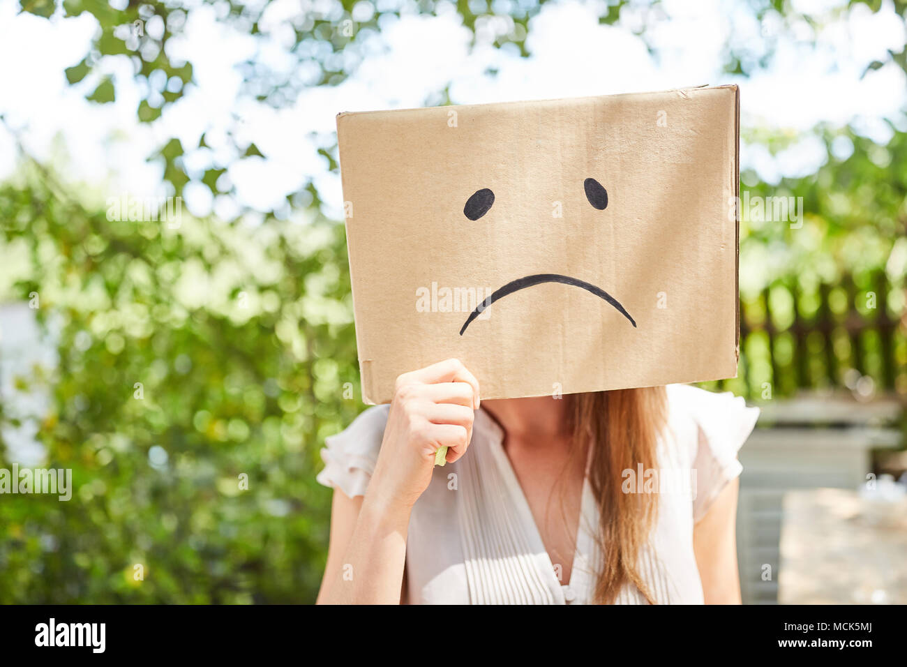 Young woman has her face hidden in cardboard box with a sad face Stock ...