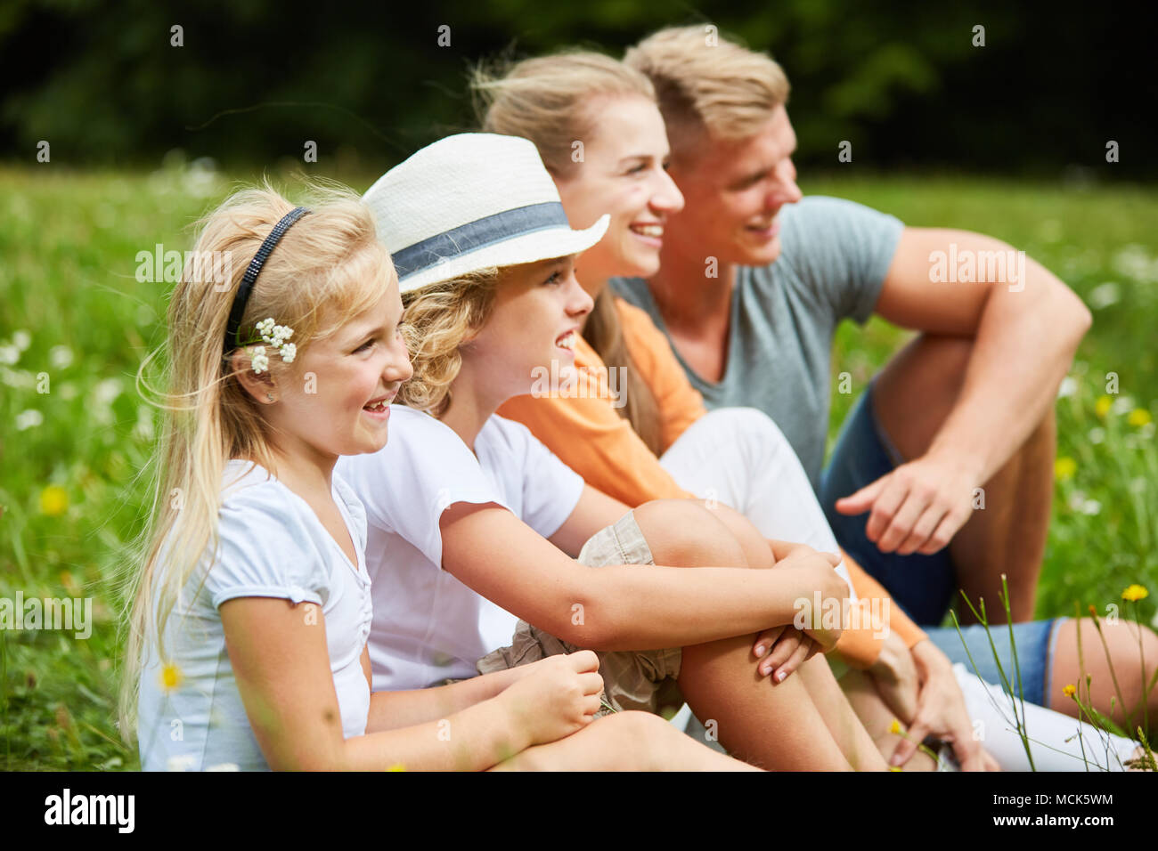 Happy family and children on a meadow look curious Stock Photo - Alamy