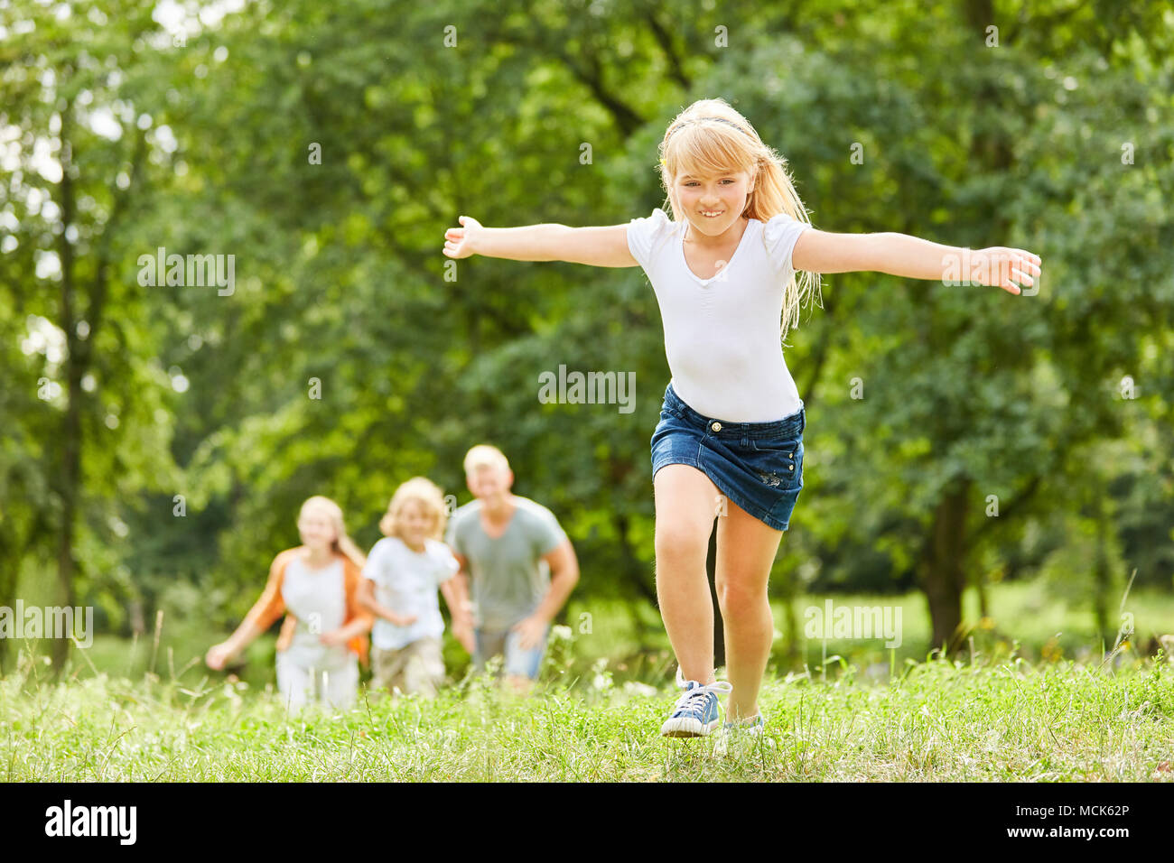 Merry blond girl is running and raging in the park during the vacation ...