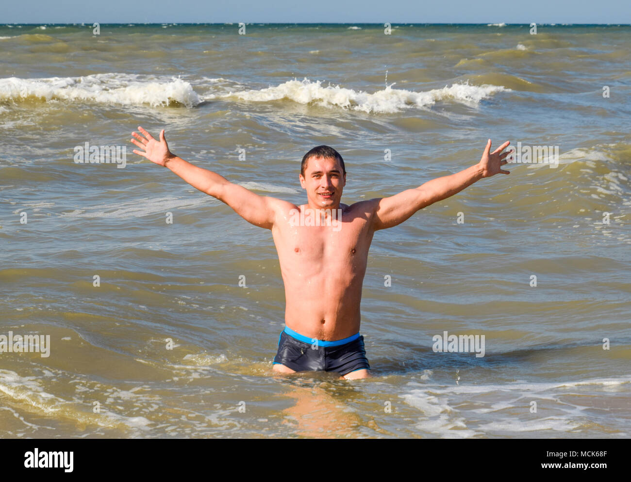sports man comes out of the sea water. Bathing in the sea. A man is ...