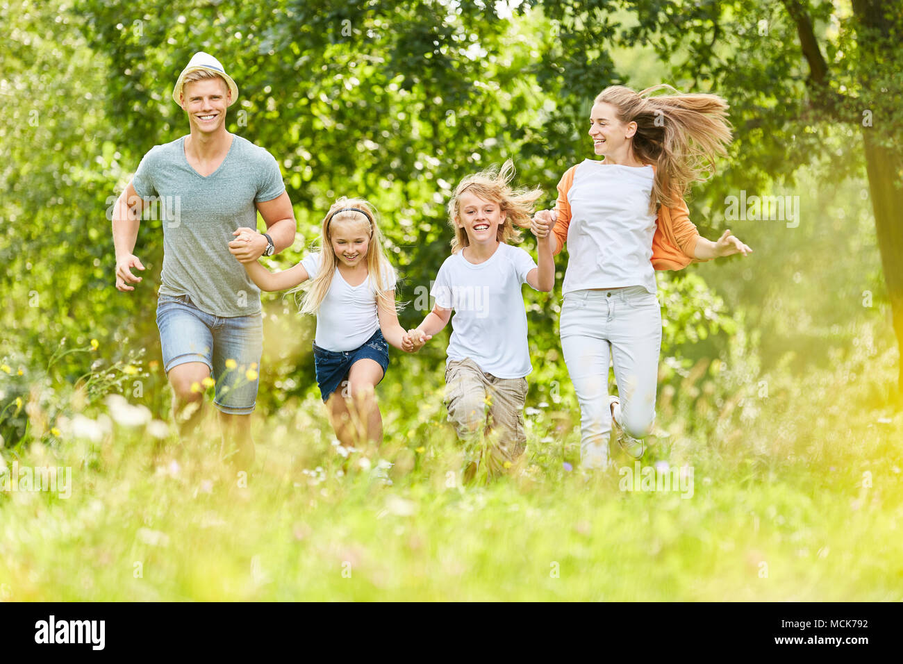 Happy family and kids run together in the spring in the garden Stock ...