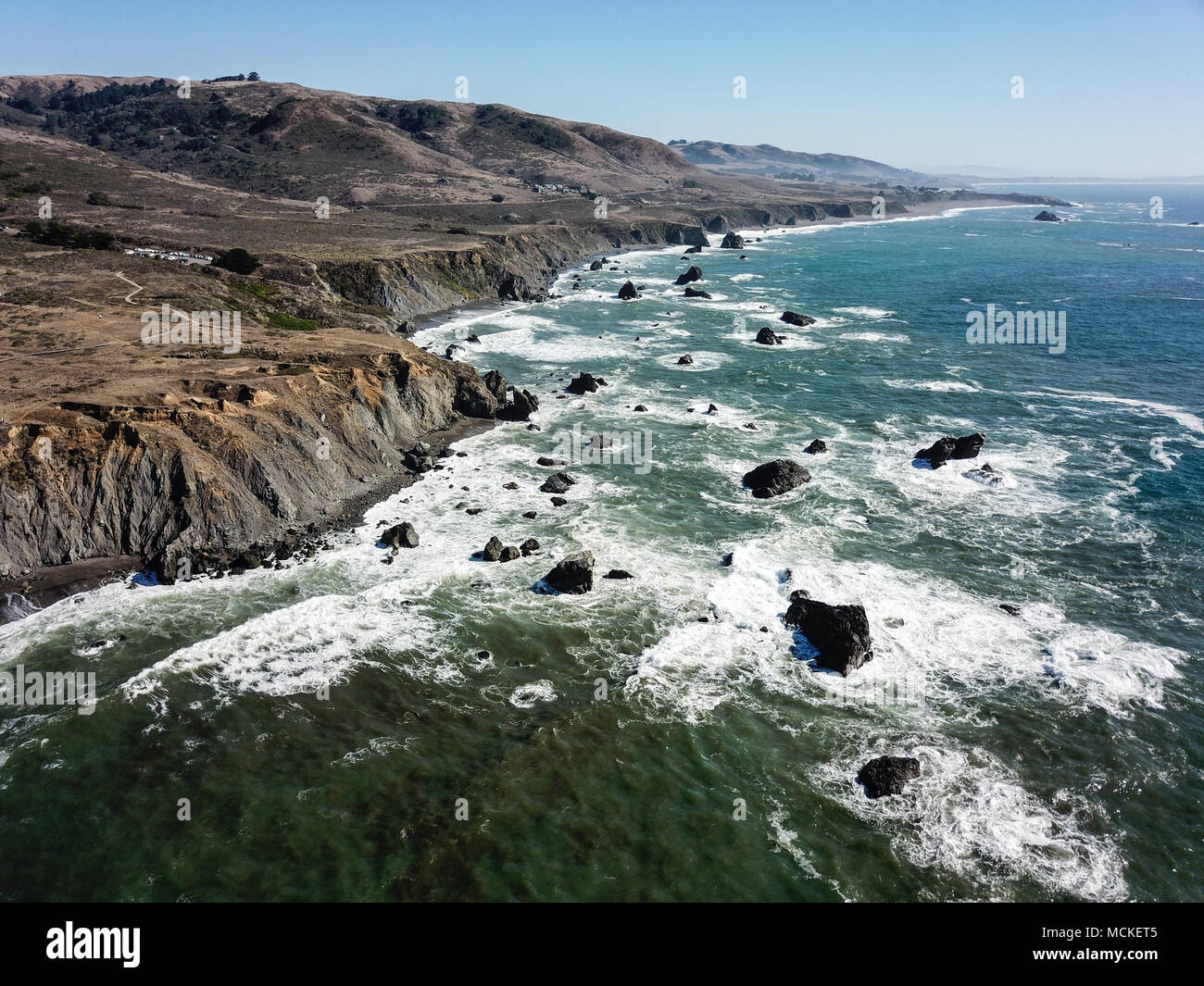The cold waters of the Pacific Ocean wash against the scenic and rugged ...