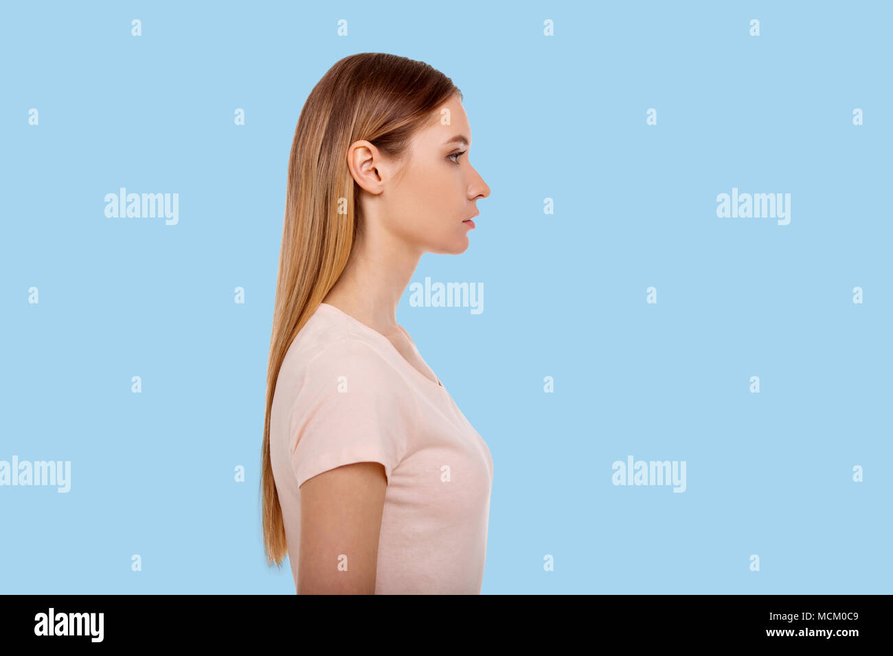 Side view of pretty woman against blue background Stock Photo - Alamy