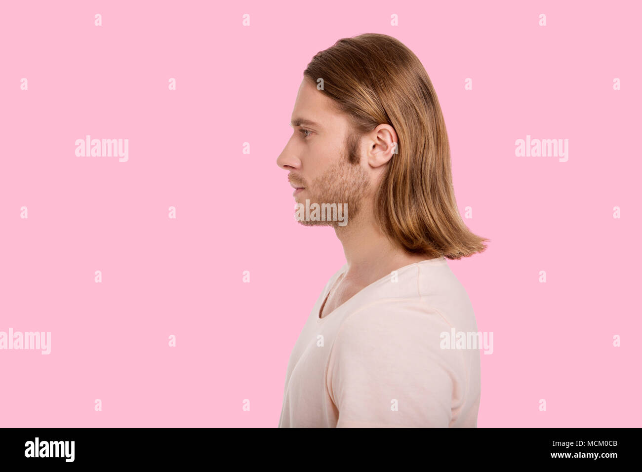 Side view of handsome man against pink background Stock Photo - Alamy