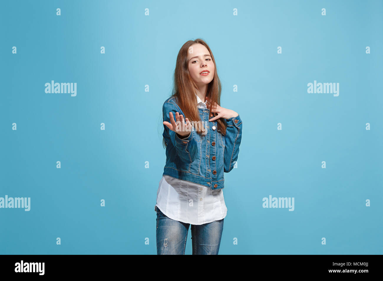 The happy teen girl standing and smiling against blue background Stock ...