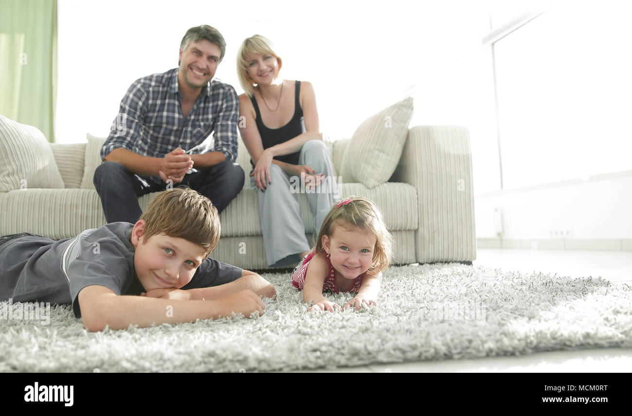 Portrait of happy family sitting together in living room Stock Photo ...