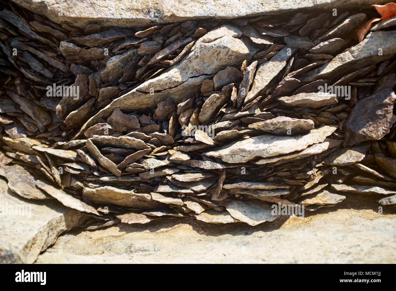 Pile of fragmented shale amongst rocks which has fractured off in thin ...