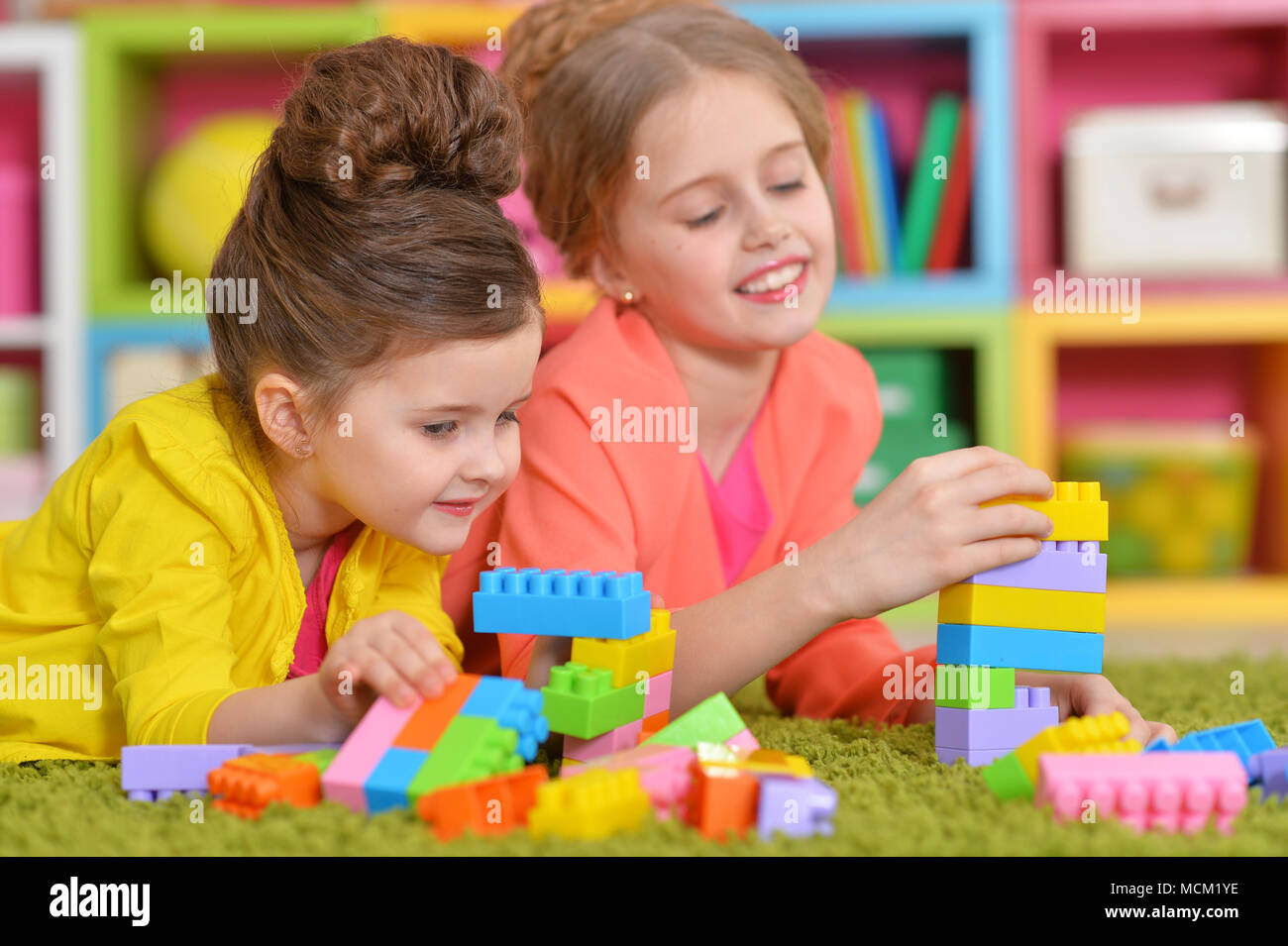 girls playing with colorful blocks Stock Photo - Alamy
