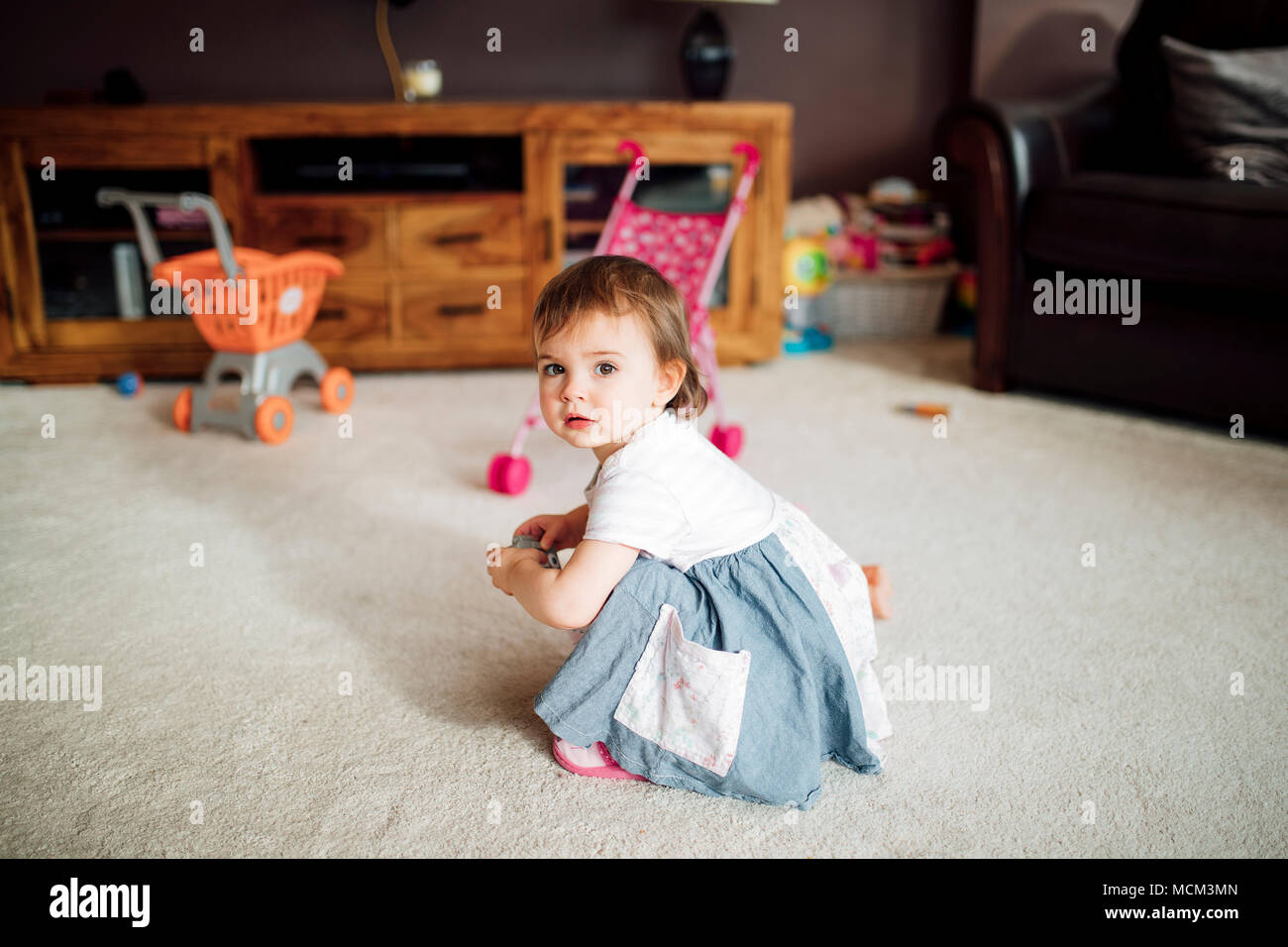 Little girl crouching on floor hi-res stock photography and images - Alamy