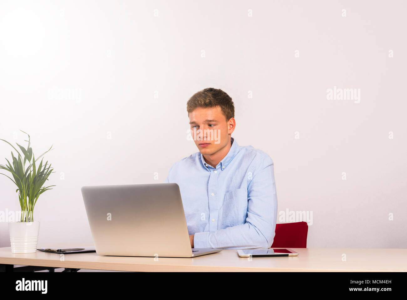Office worker using computer on table, male caucasian young Stock Photo ...
