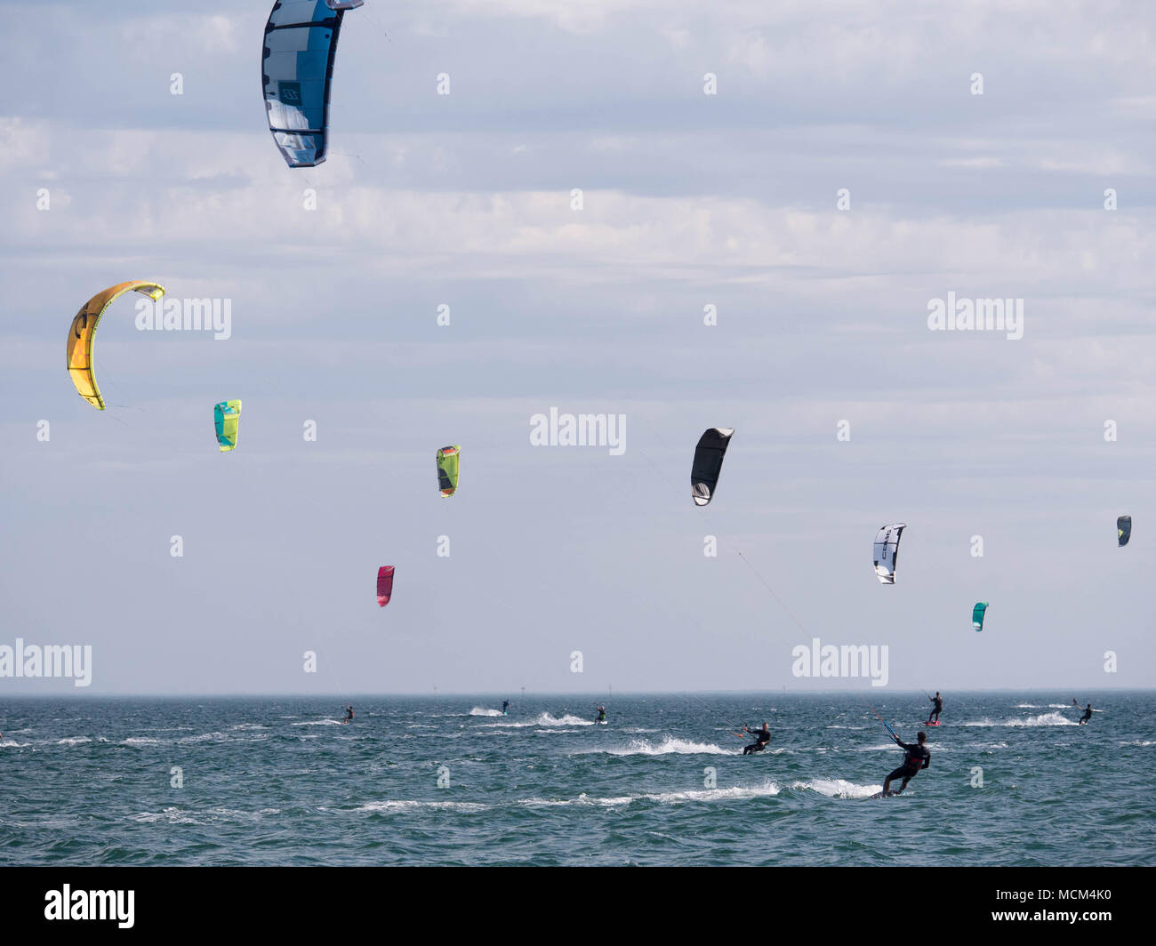 Numerous multicolored kiteboarders on horizon of Port Phillip Bay on ...