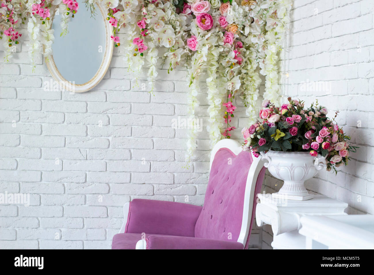 Room decorated with flowers and mirror in loft interior room with ...