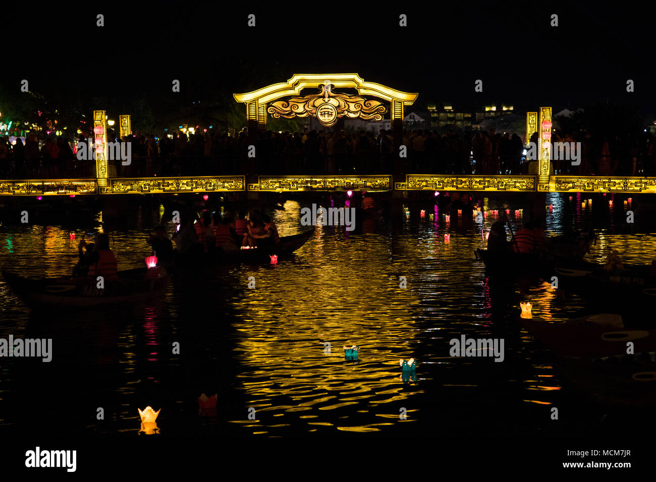 Row boats on the Thu Bon River next to the Lantern Bridge in Hoi An ...