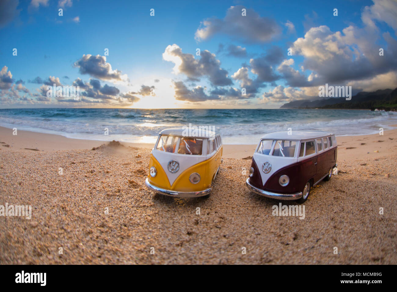Two toy buses at beach during sunrise Stock Photo - Alamy