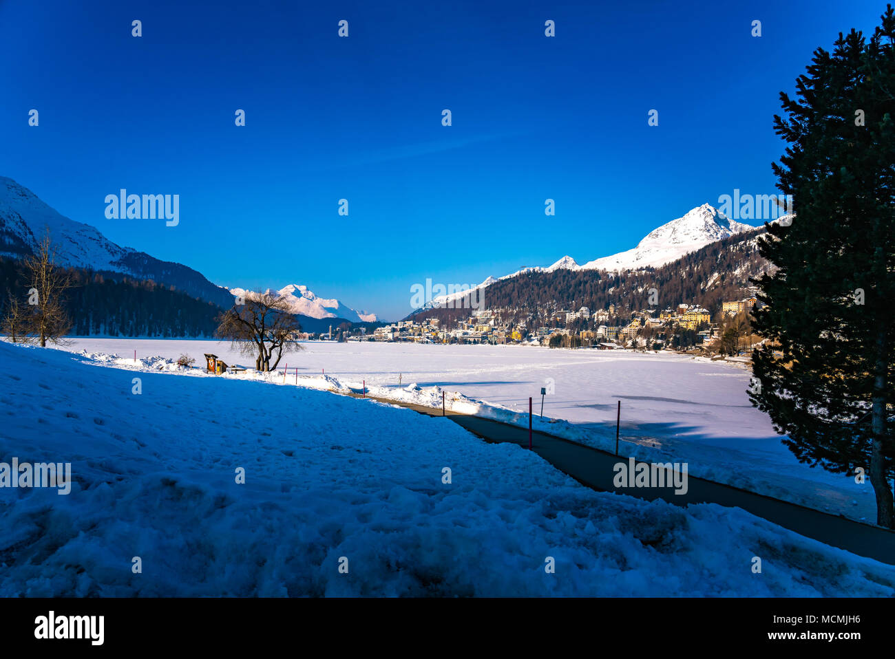 View of a luxury alpine resort town St. Moritz and the frozen lake ...