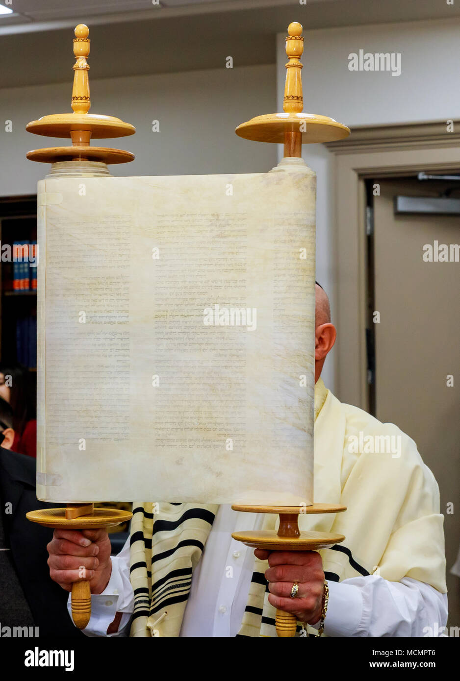 A Jewish man holding Torah scrolls in the synagogue of Orthodox Jews ...