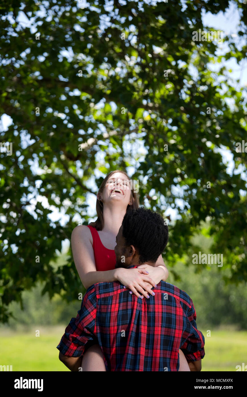 Couple embracing one another in a park Stock Photo - Alamy