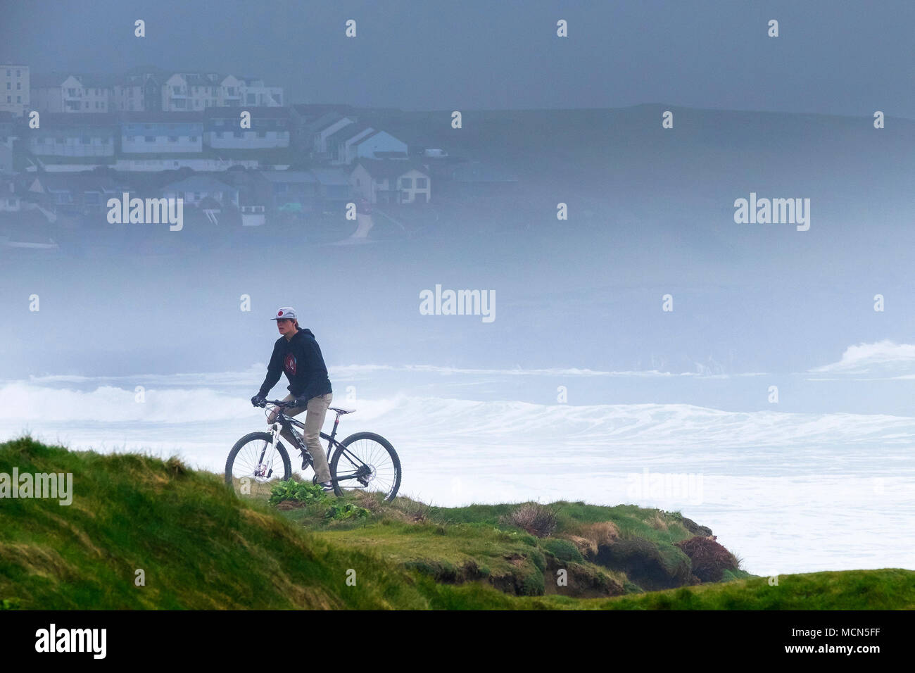 UK weather - a cyclist on the coast overlooking the sea in misty ...