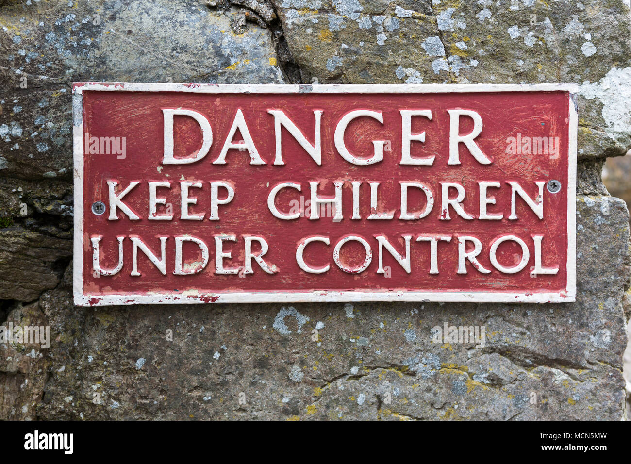 Sign on wall says Danger Keep Children Under Control Stock Photo - Alamy