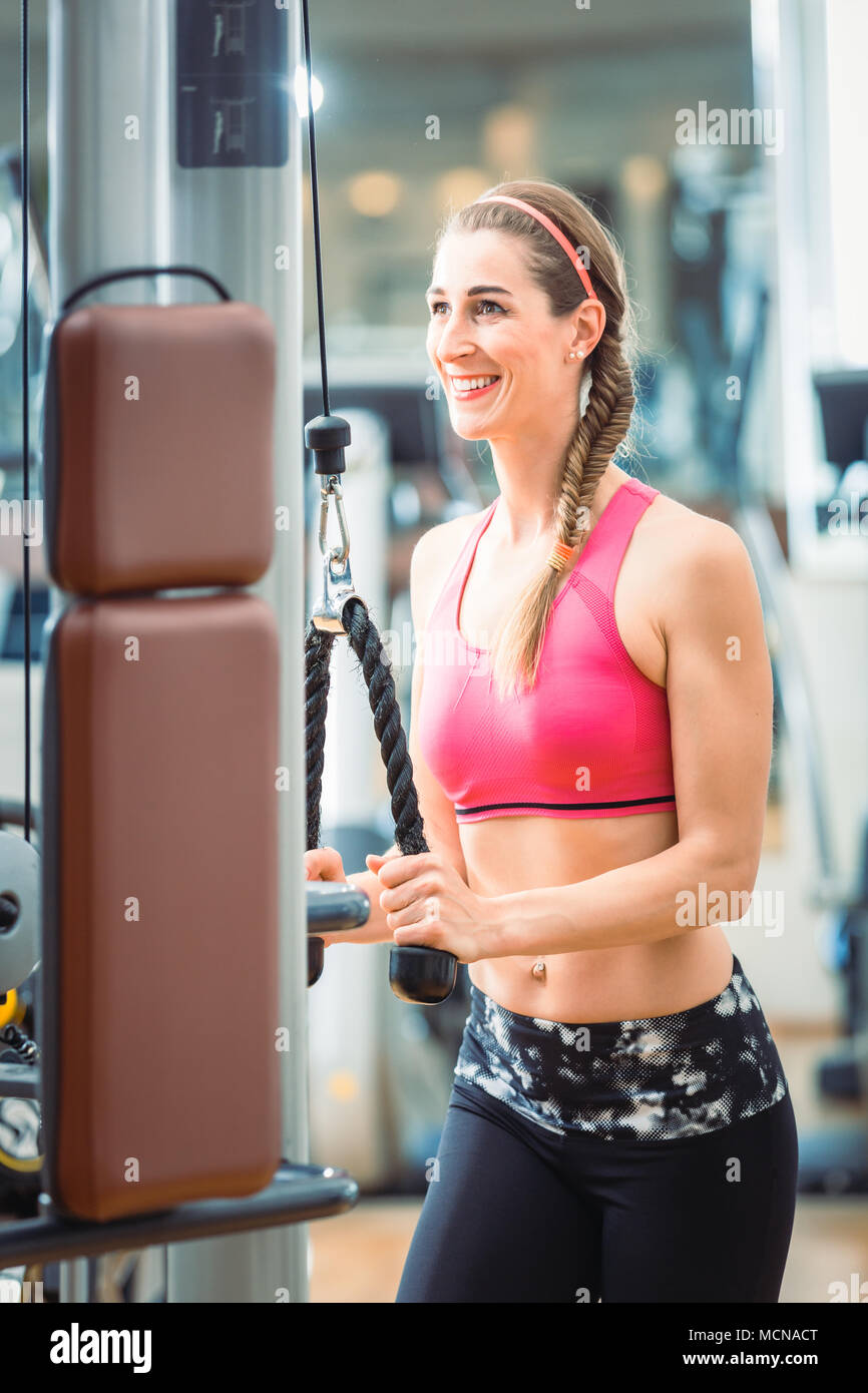 Happy fit woman wearing pink fitness bra while exercising at the gym ...
