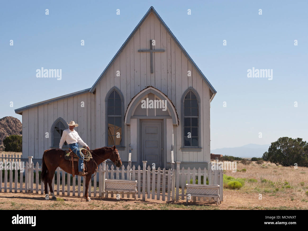 Cowboy on horseback in front of church in old west town Stock Photo - Alamy
