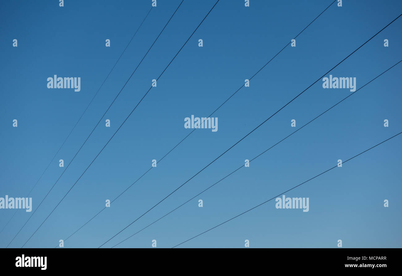 High voltage power wires against sky, network. Blue clear sky and ...