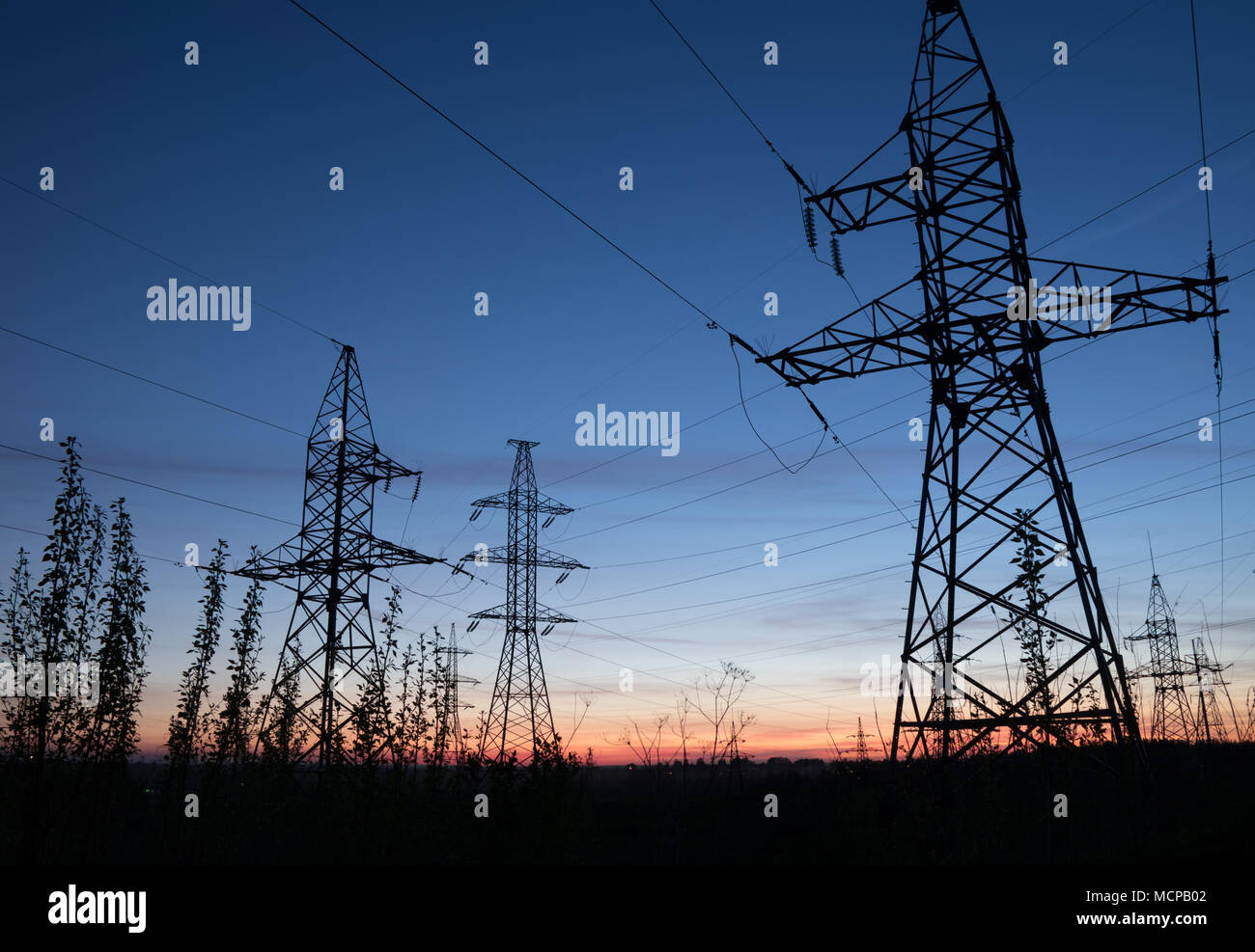 High voltage electricity pylons against sunset. Electric pole power ...