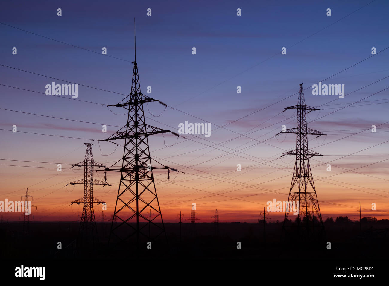 High voltage electricity pylons, sunset. Electric pole power lines and ...