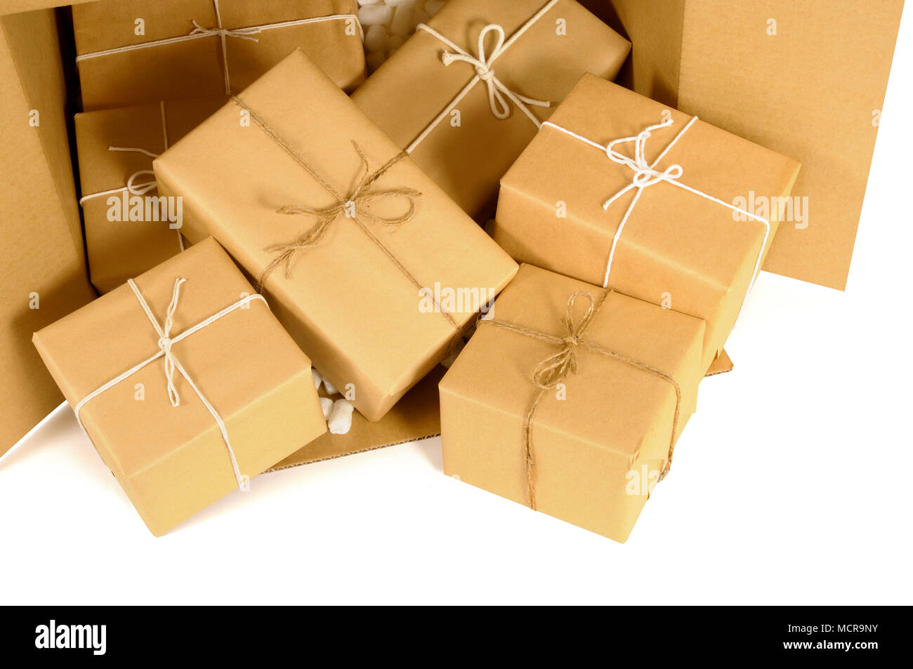 Cardboard shipping box with several brown paper packages inside Stock ...