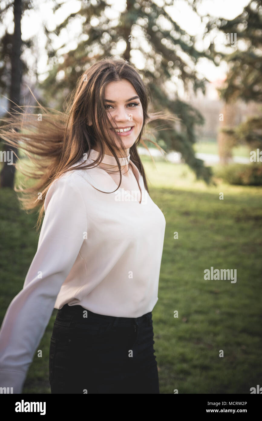Svelte Girl in motion in the park smiling Stock Photo - Alamy
