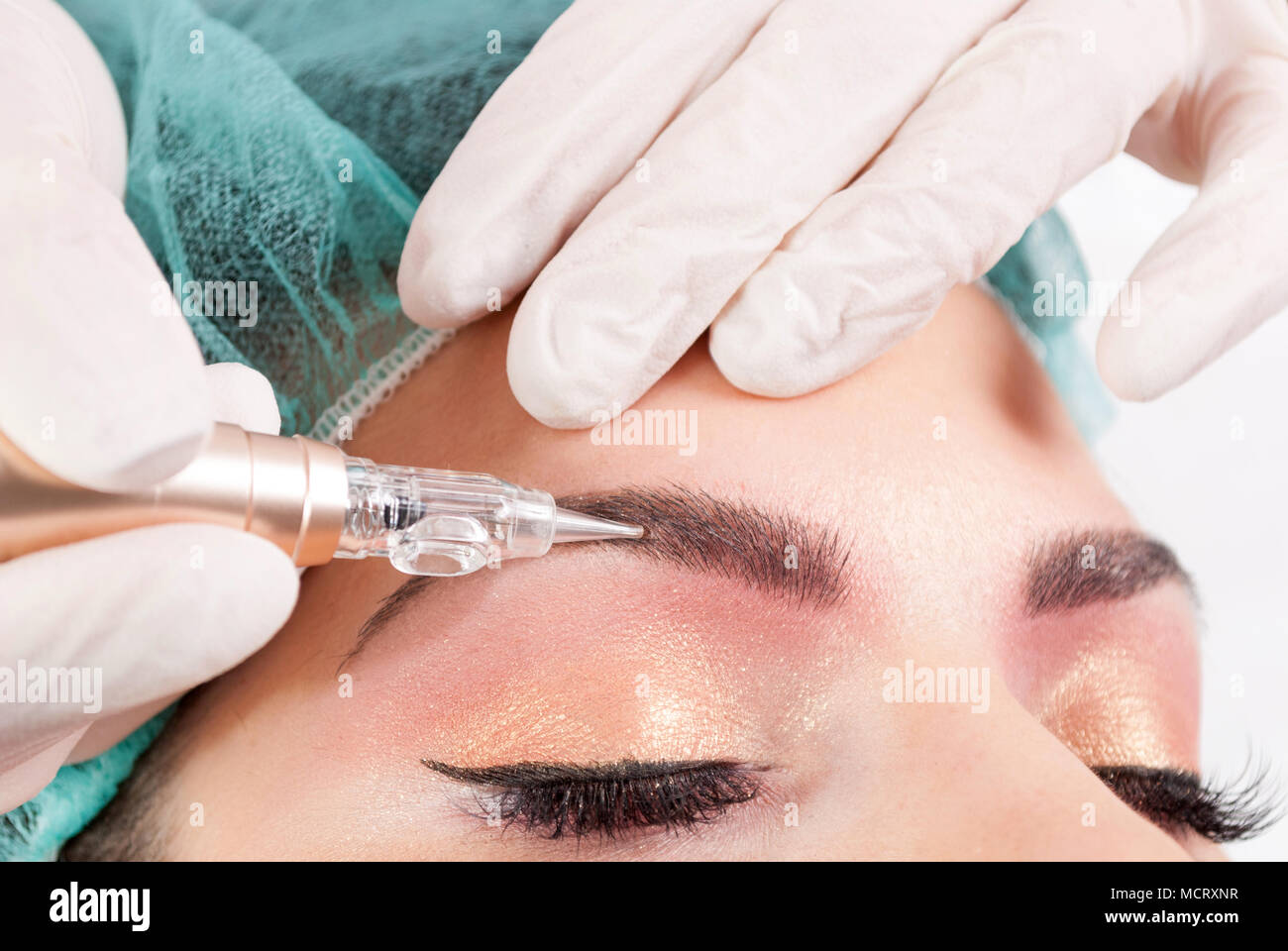 Applying permanent Makeup for Eyebrows. Beautician Doing Eyebrow ...
