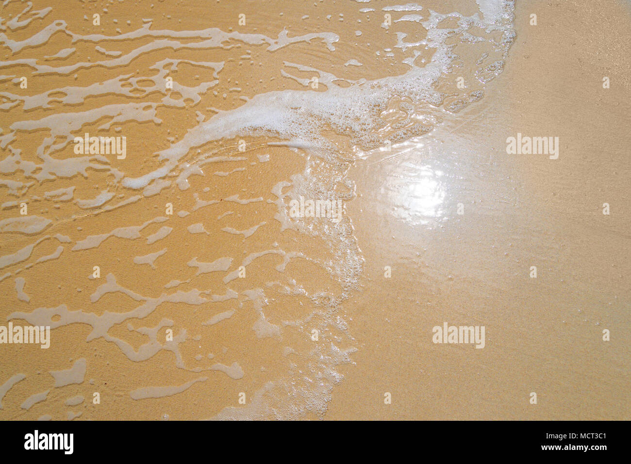 Sand beach water background. reflection of the sun on the sandy beach ...