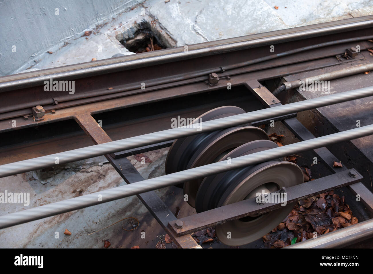Funicular details. Rails, moving traction cable and support rollers ...